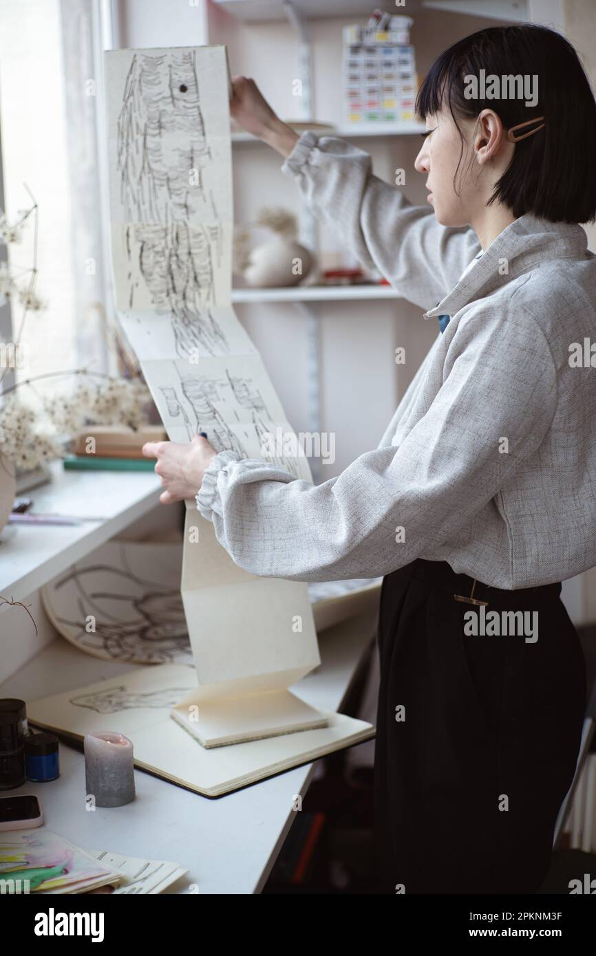 female artist look at her work drawing with pen and black ink. Graphic ...