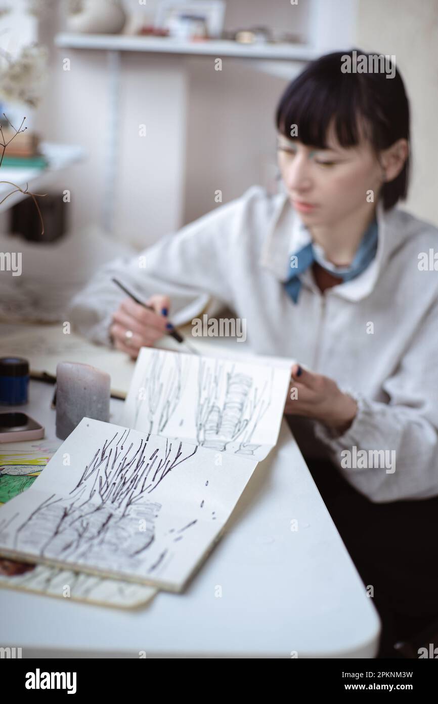 Female artist drawing painting with pen and black ink. Graphic Painting ...