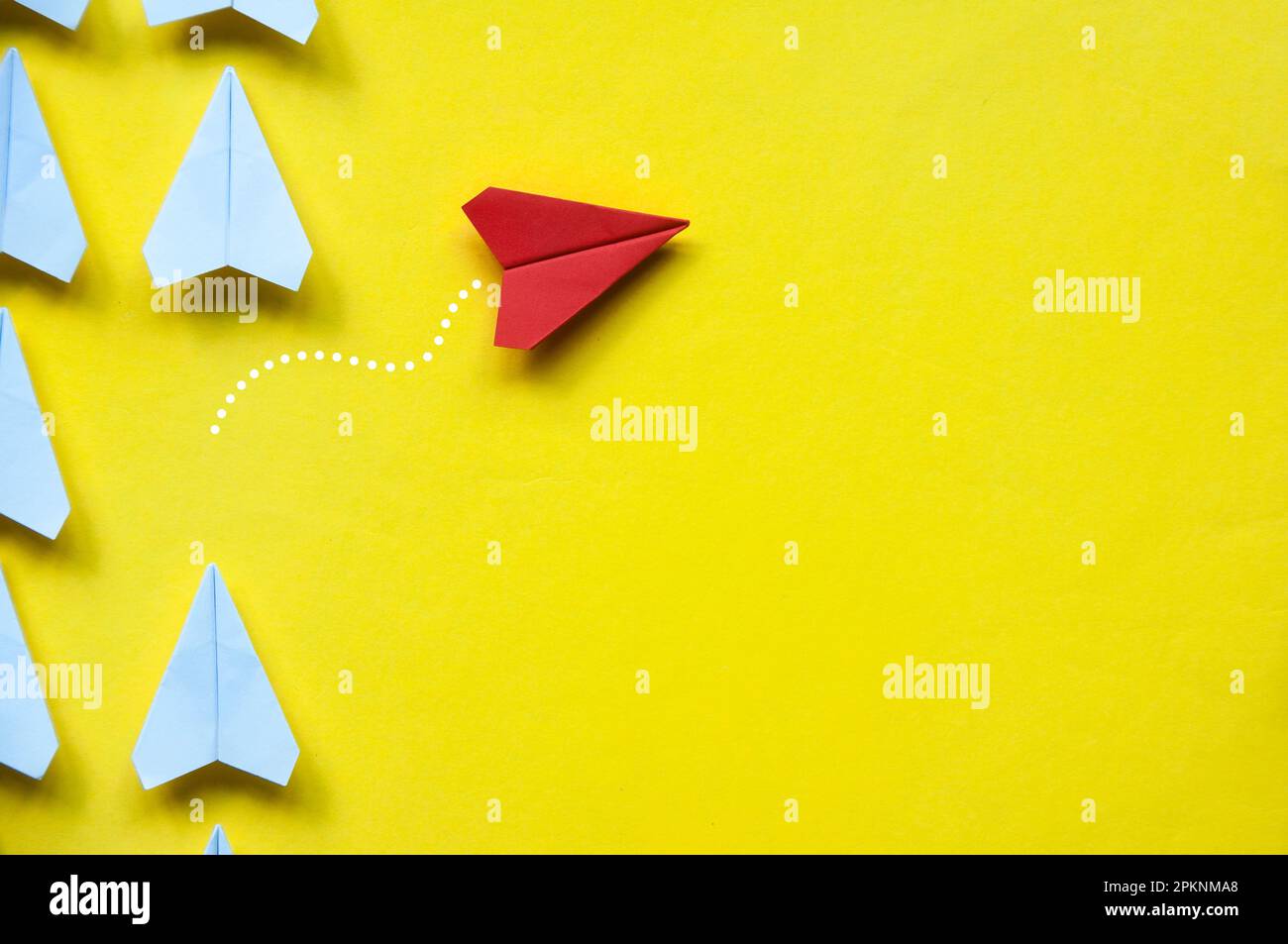 Top view of red paper airplane origami leaving other white airplanes on ...