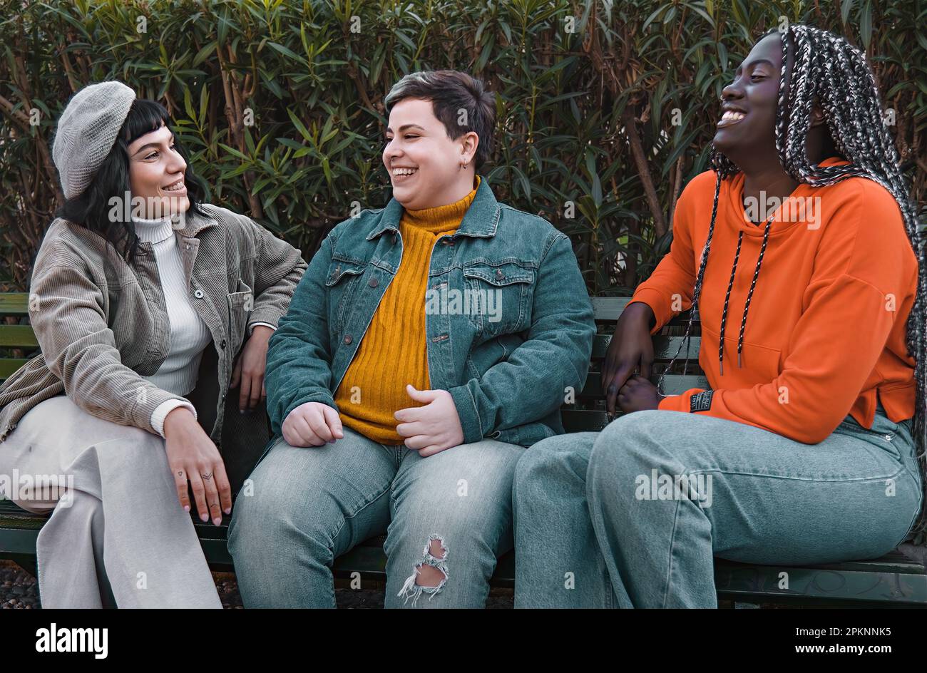 Three diverse young friends, a brunette woman, a non-binary plus size ...