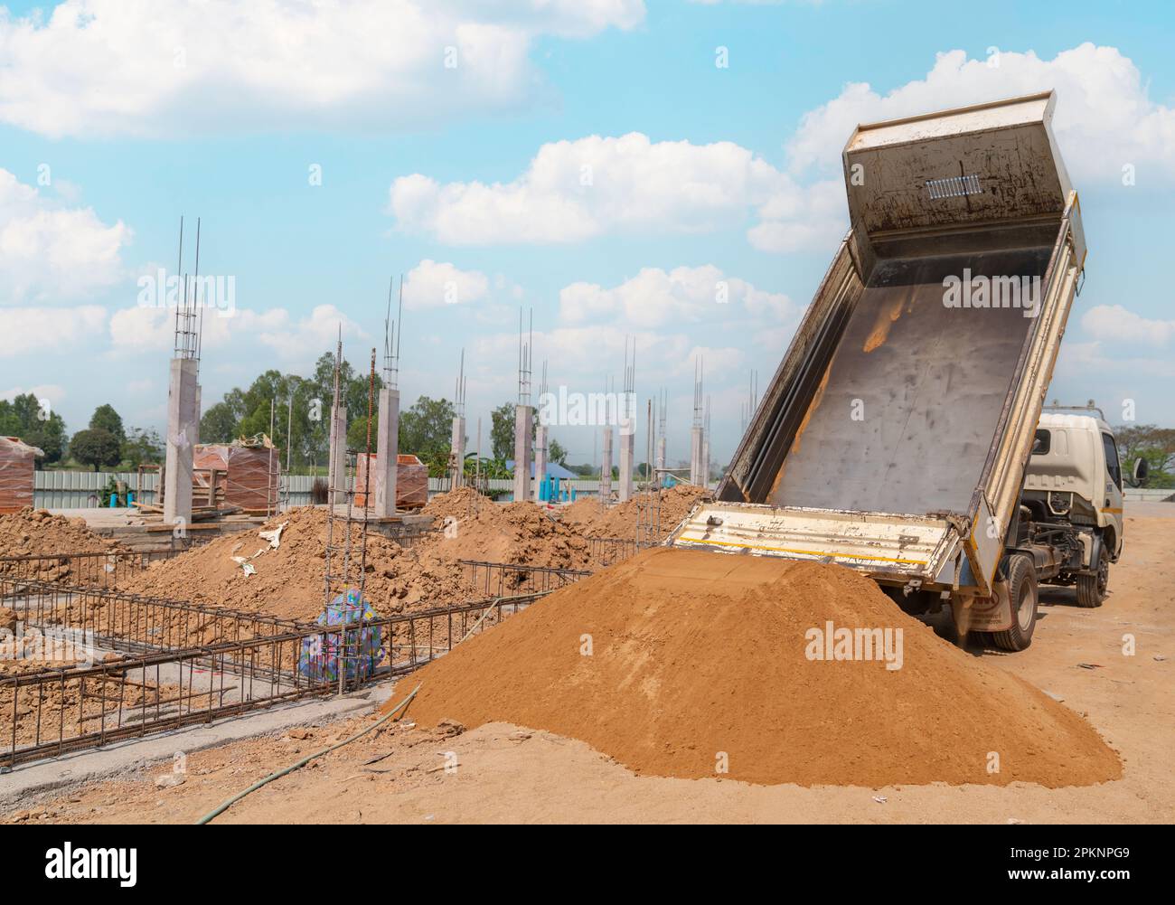 Truck dumping and tipping sand for new building and blue sky Stock ...