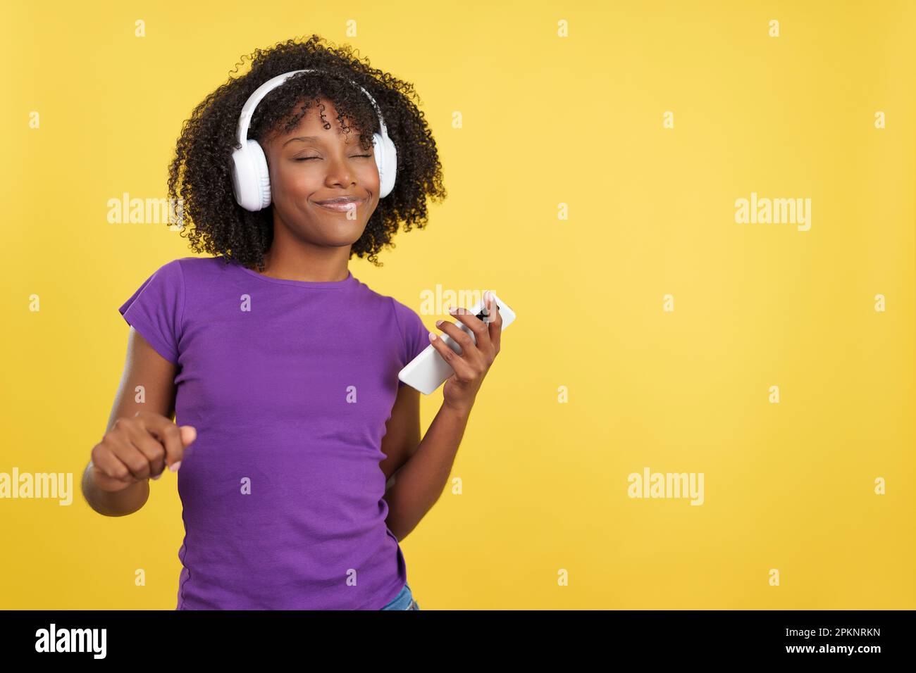 Cool afro woman listening to music with headphones and mobile Stock ...