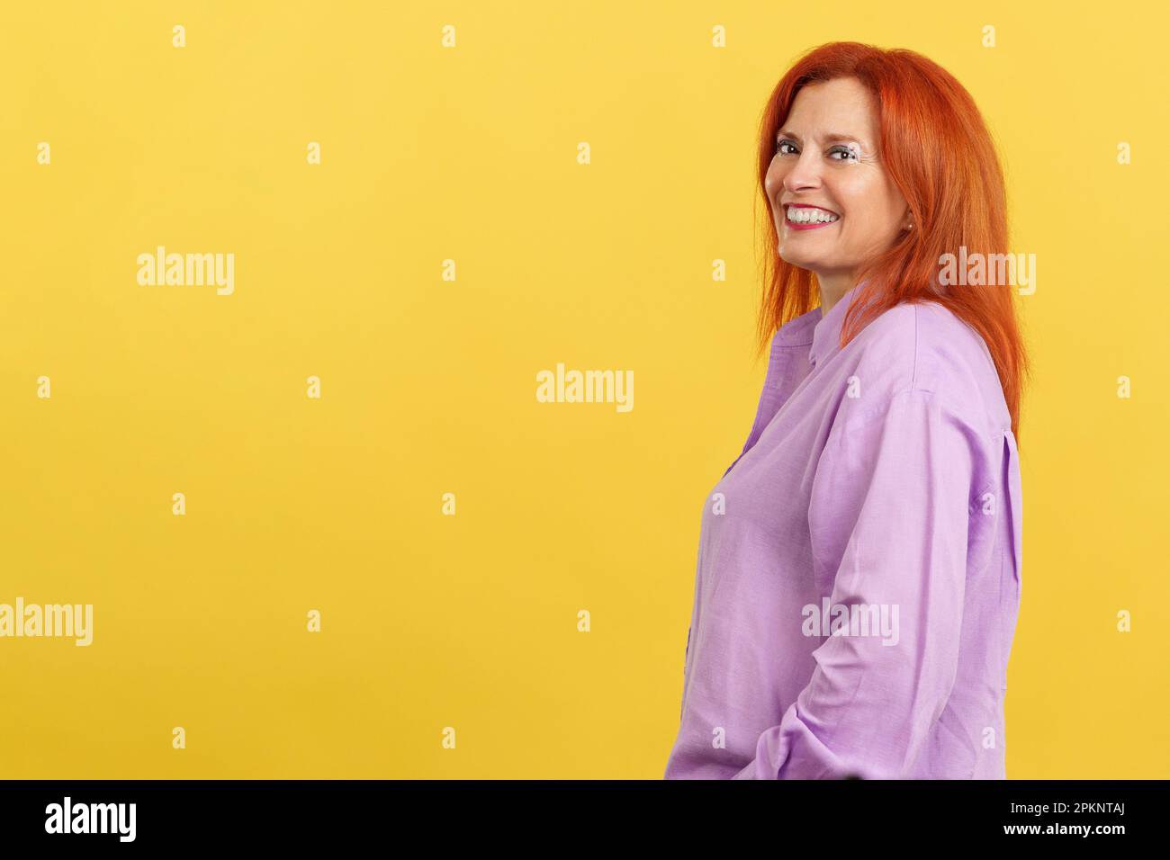 Happy redheaded mature woman smiling at the camera Stock Photo - Alamy