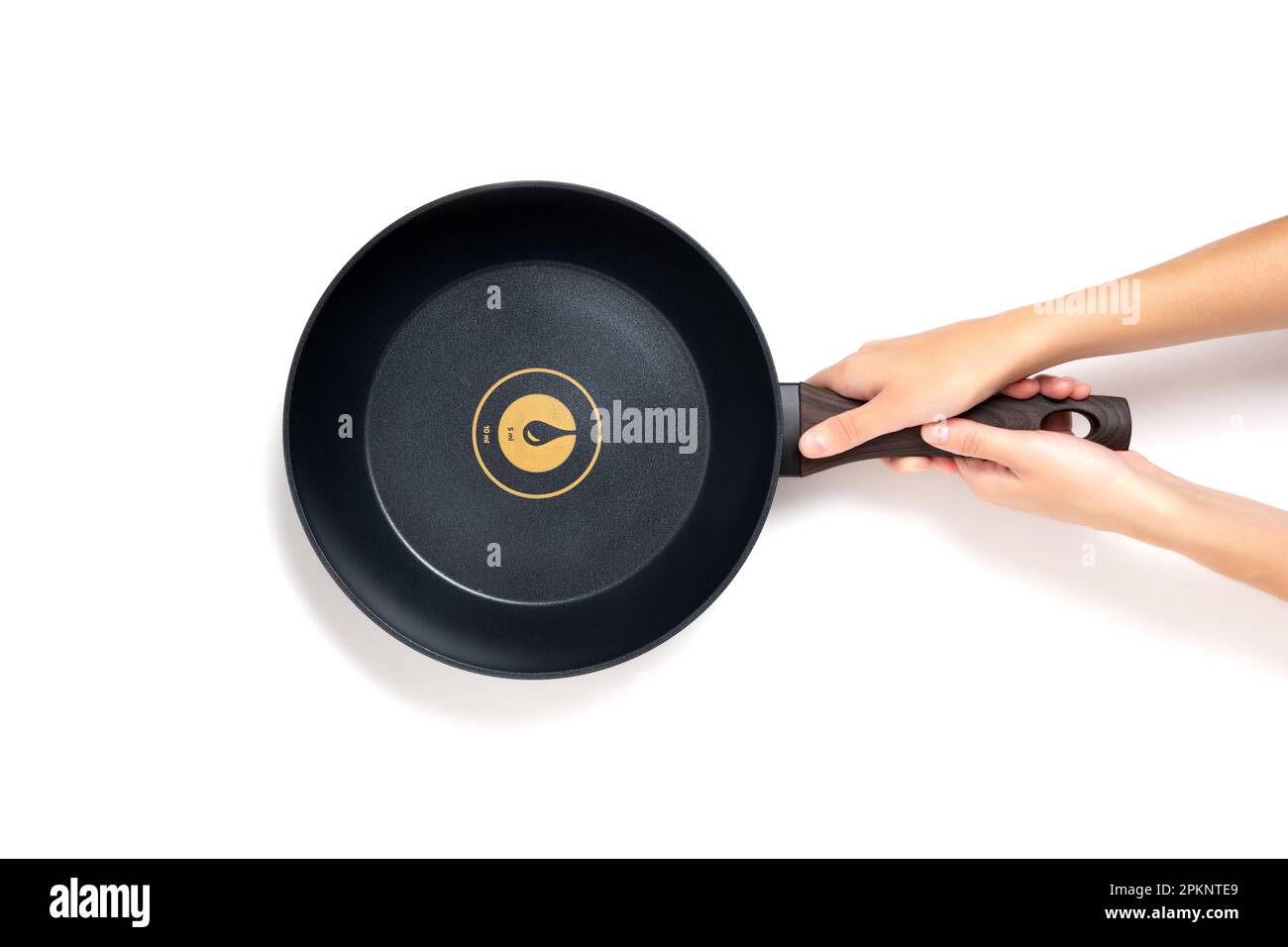 Crop view of female hands holding a new empty frying pan with a non ...