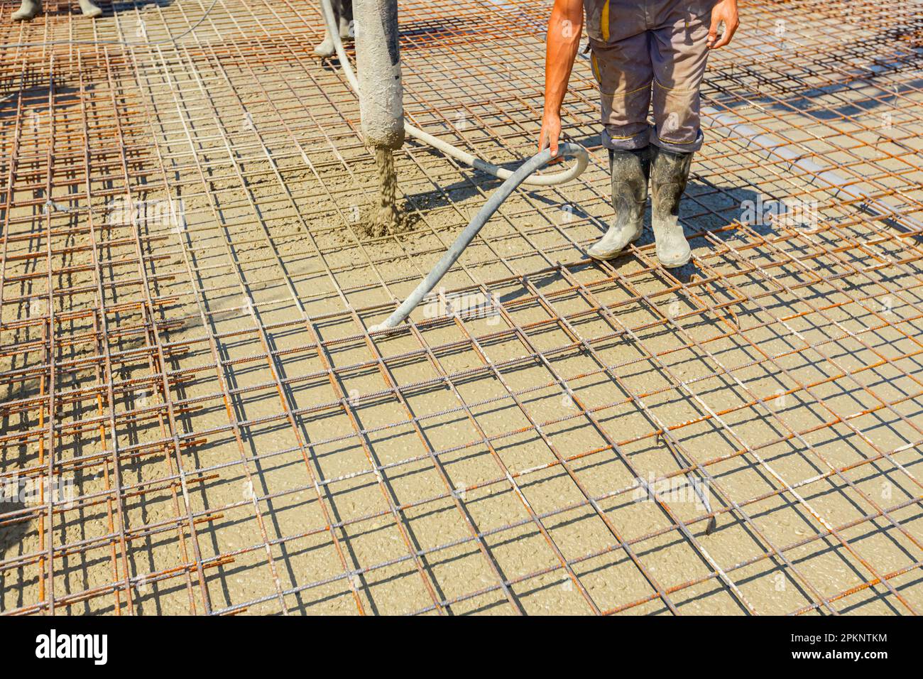 Worker is using vibration power tool, compactor, for compacting fresh ...