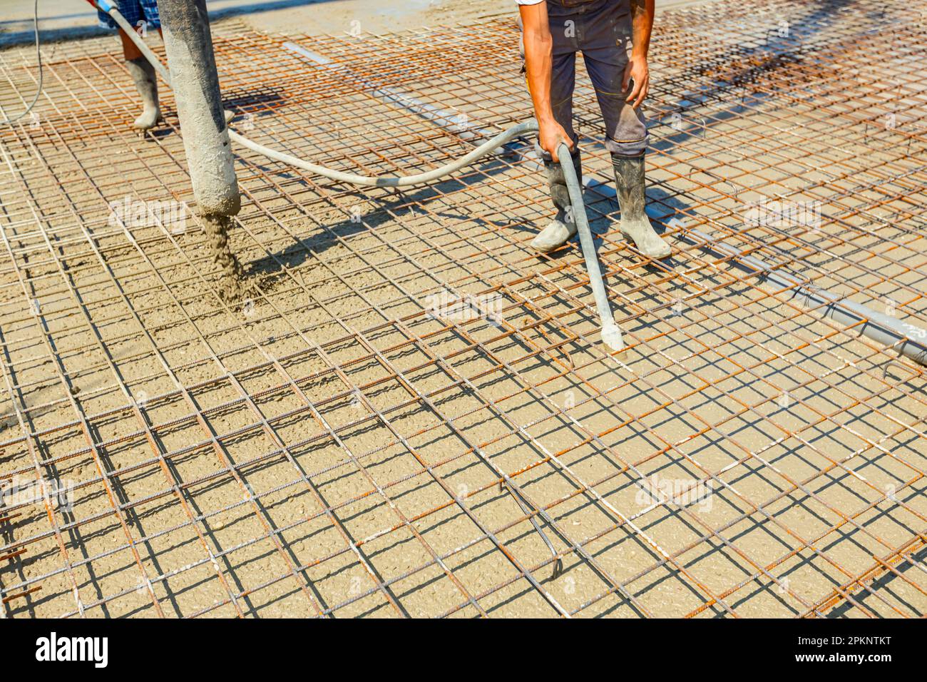 Worker is using vibration power tool, compactor, for compacting fresh ...