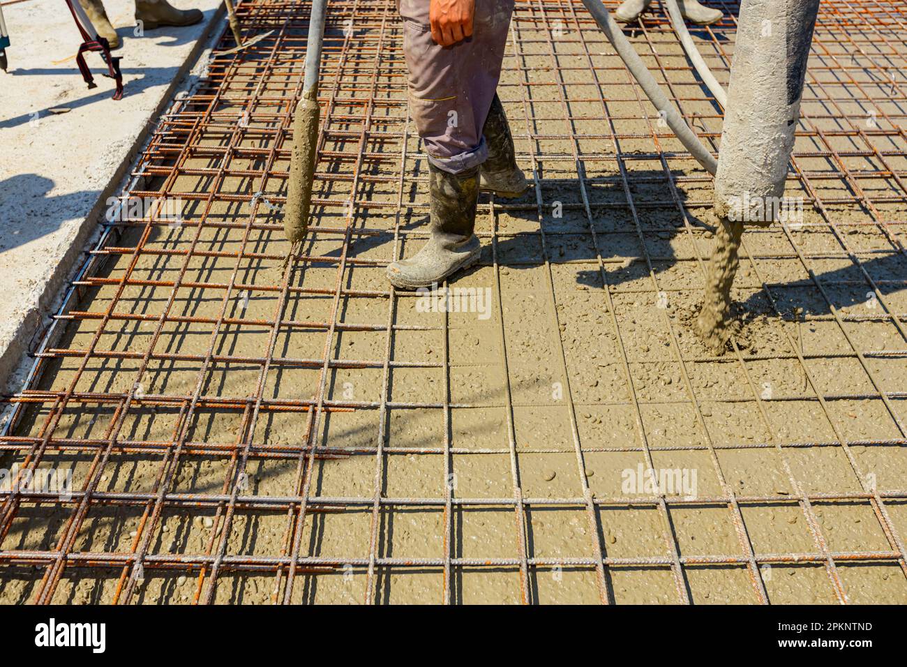 Worker is using vibration power tool, compactor, for compacting fresh ...