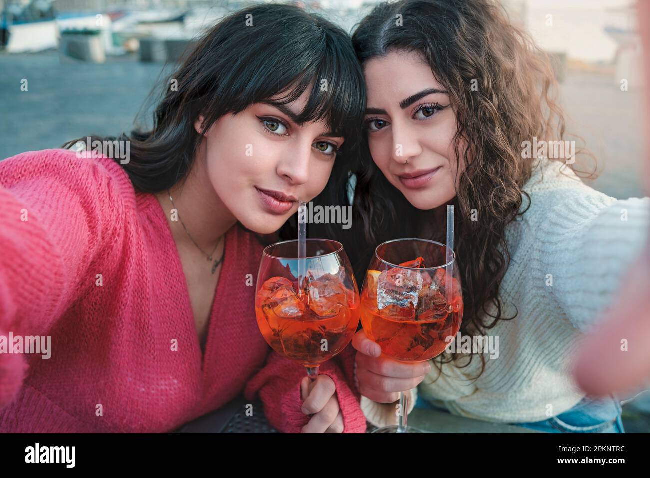 Two Caucasian Girls 21 Years Old Taking A Selfie With A Spritz In Hand With A Pier In The 