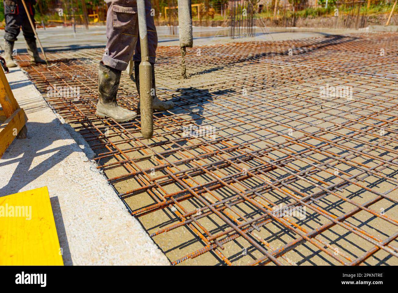 Worker is using vibration power tool, compactor, for compacting fresh ...