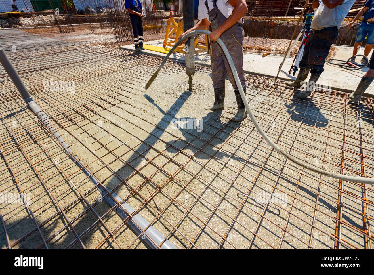 Worker is using vibration power tool, compactor, for compacting fresh ...