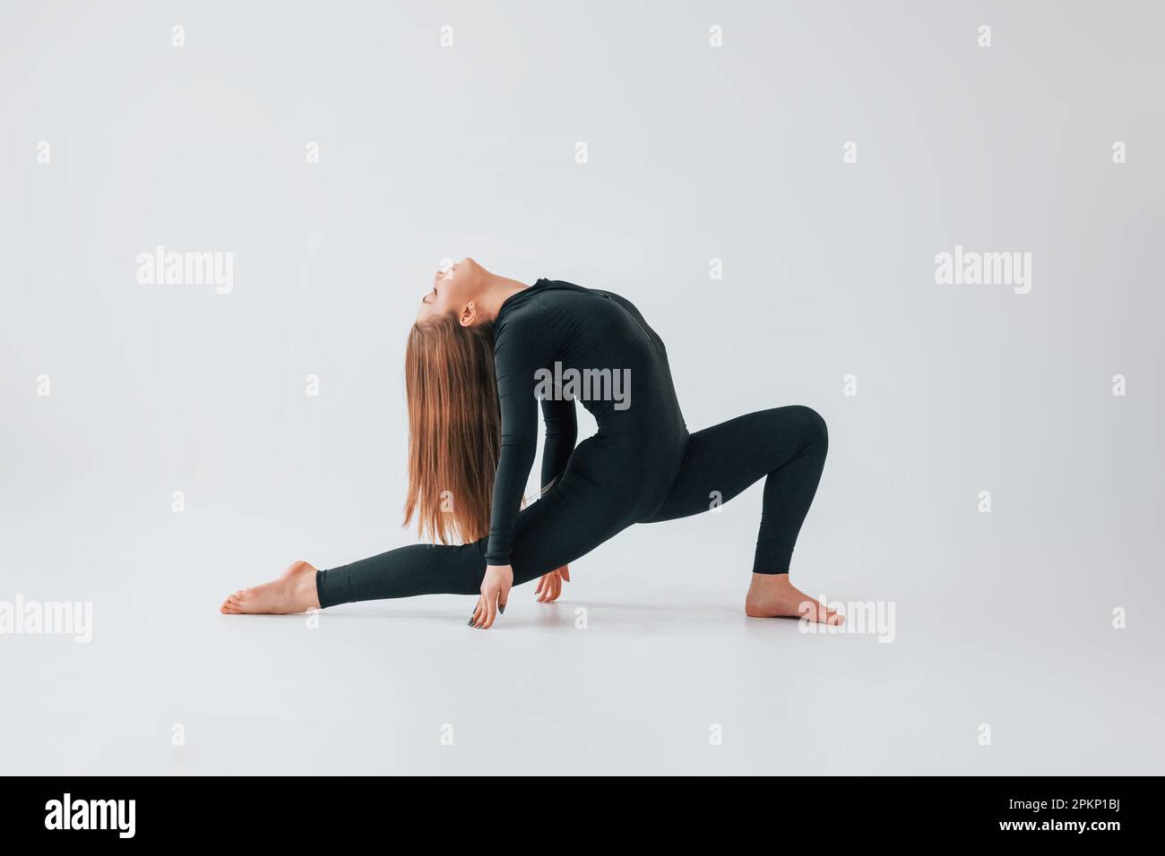 On The Floor Young Woman In Sportive Clothes Doing Gymnastics Indoors