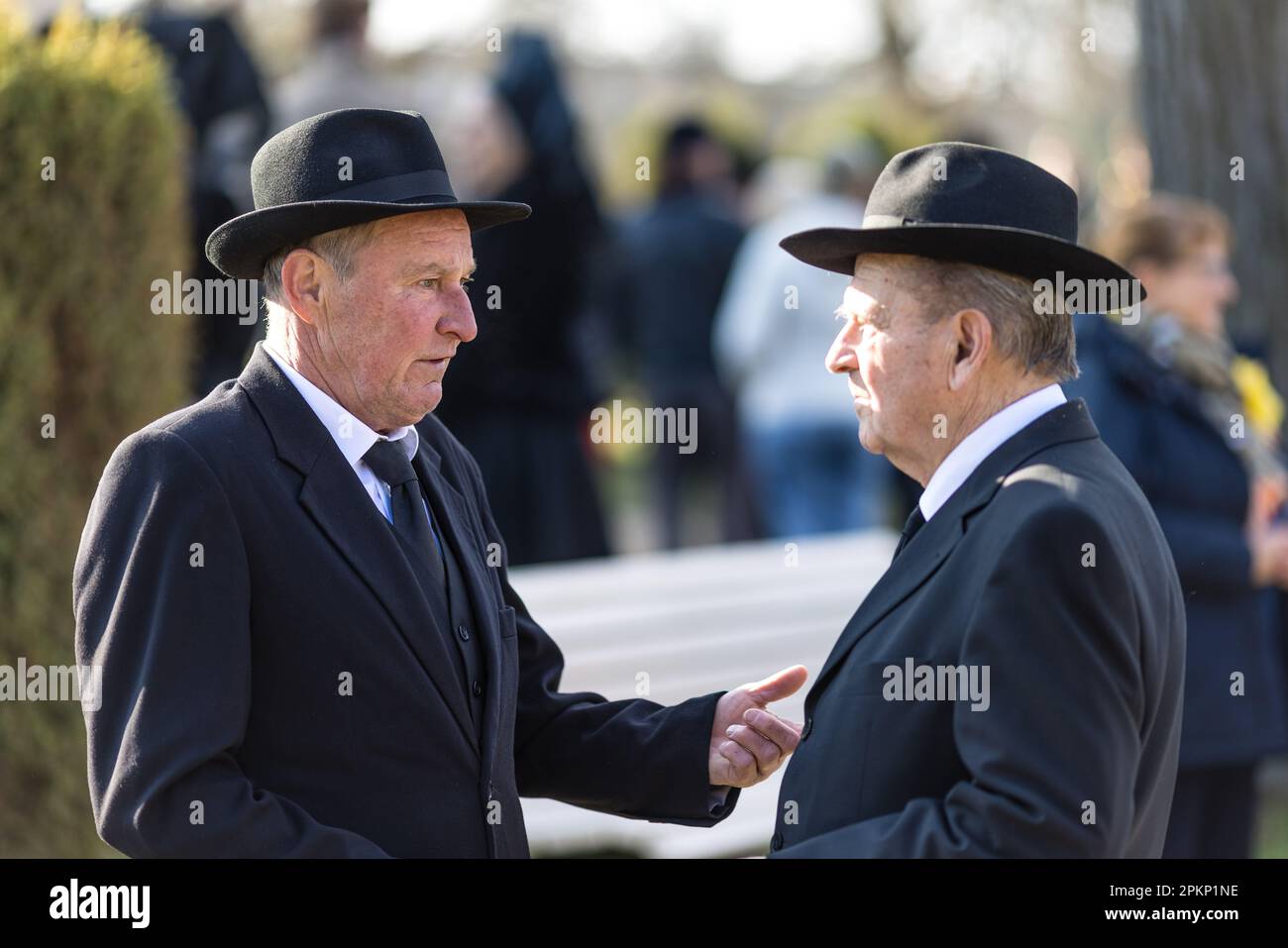 09 April 2023, Brandenburg, Burg (Spreewald): Men in black suits stand ...