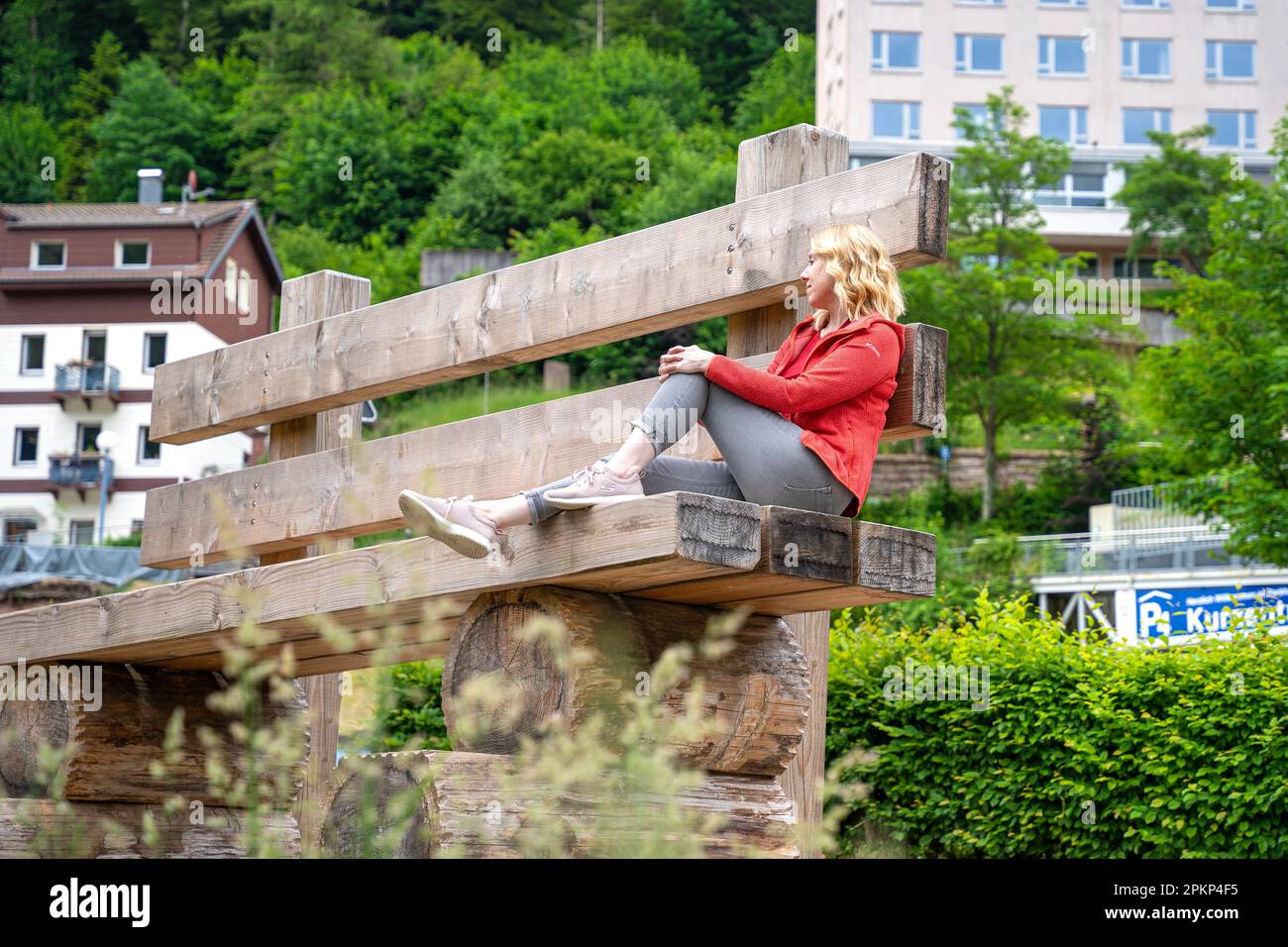 Woman sitting on huge bench in spa gardens, Bad Wildbad, Black Forest ...