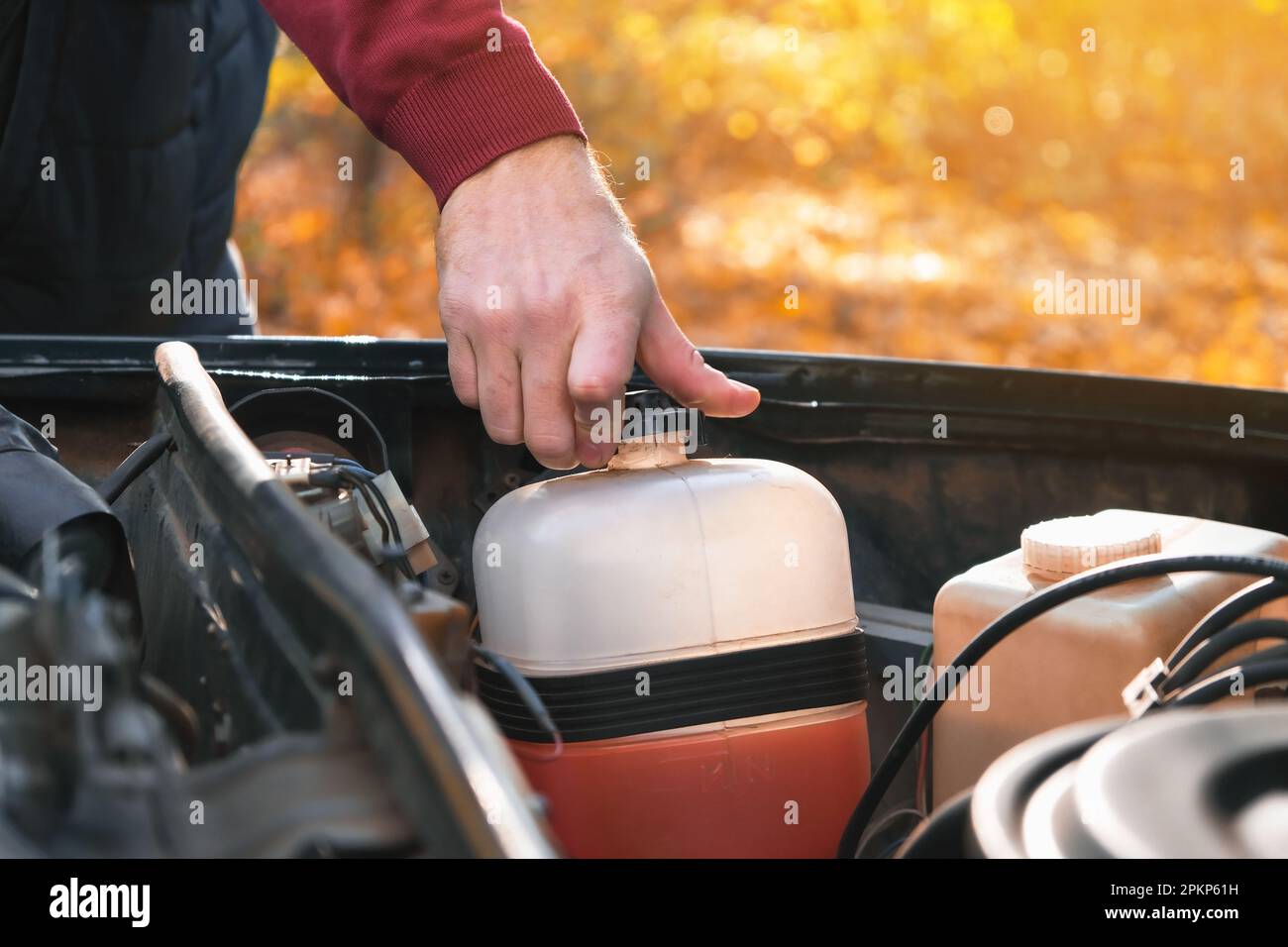 A man checks the level of technical fluids of the car. Self-service of ...