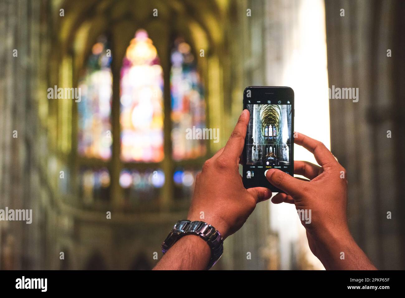 Close up hands holding mobile phone directed to the window in a church ...