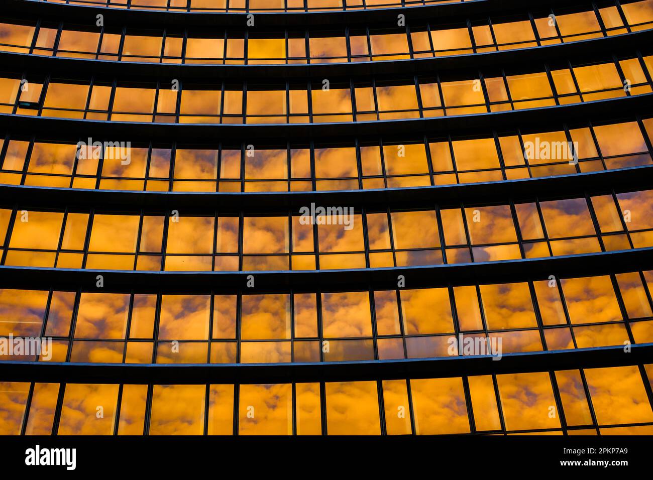A bright backdrop featuring a modern orange glass building reflecting ...