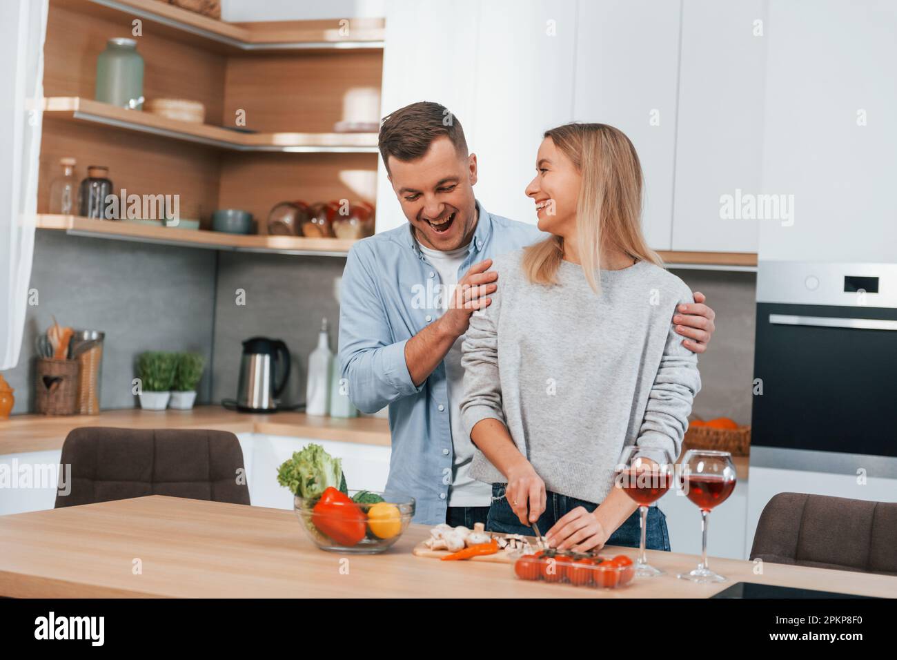 Cute people. Couple preparing food at home on the modern kitchen Stock ...
