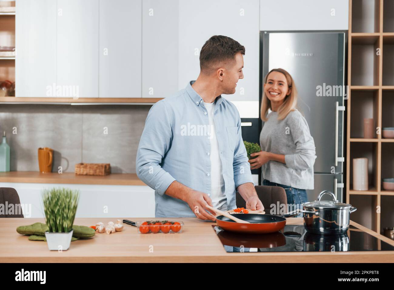 Preparing dinner. Couple at home on the modern kitchen Stock Photo - Alamy