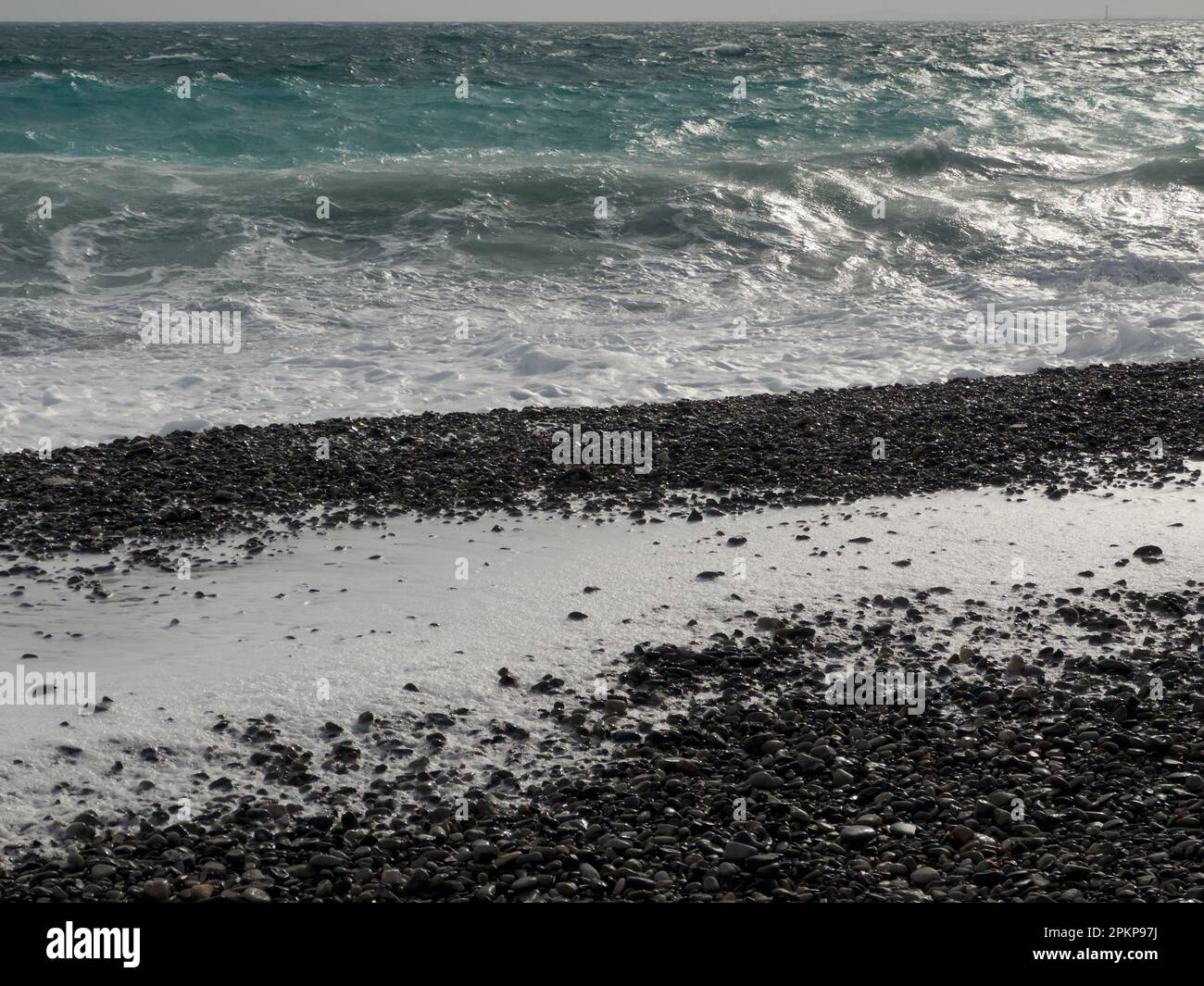 Pebble beach of Nice, France with azure waves of mediterranean sea ...