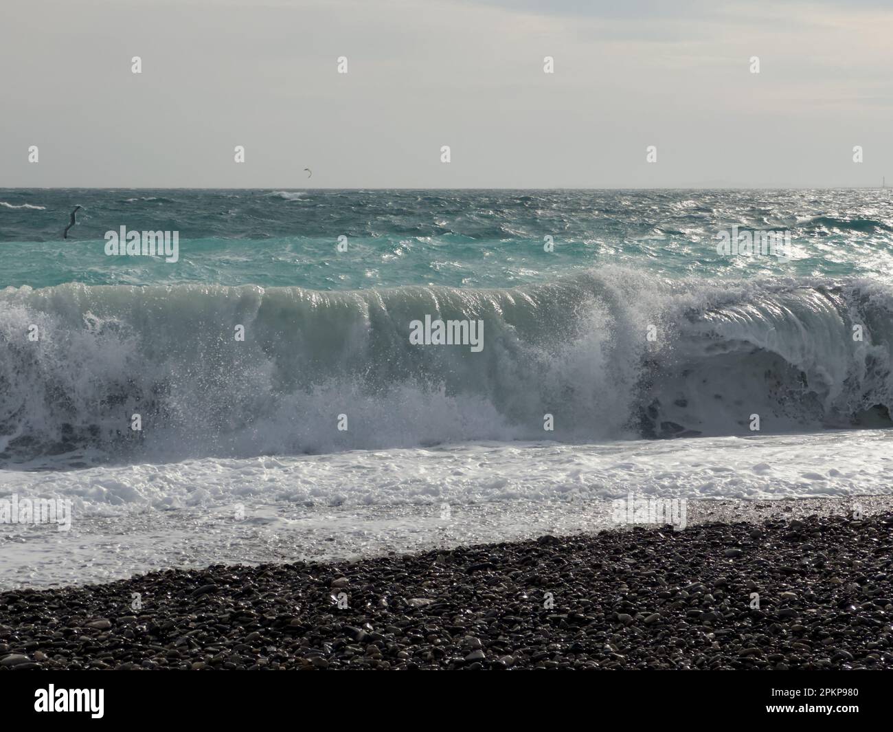 Pebble beach of Nice, France with azure waves of mediterranean sea ...