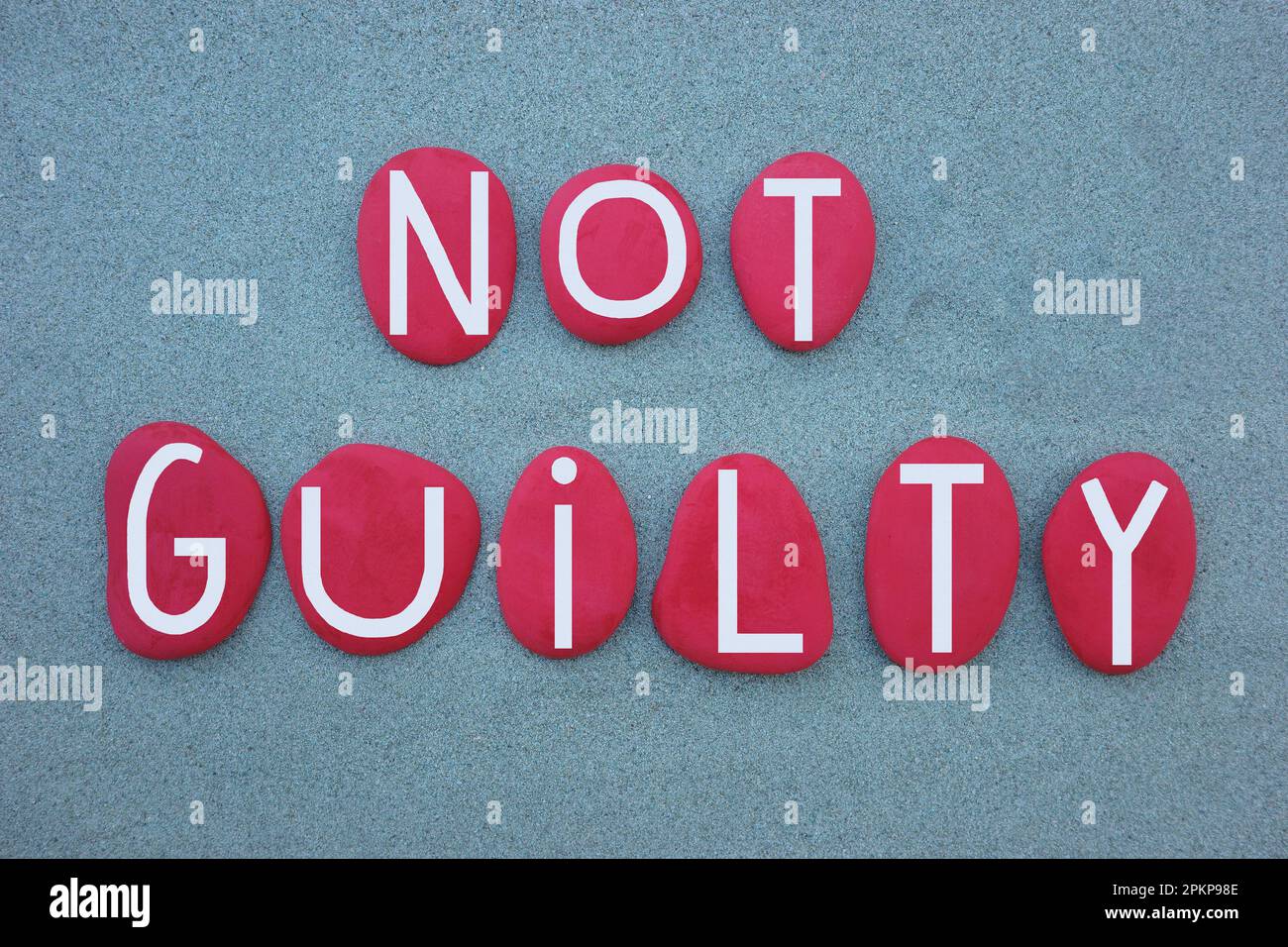 Not Guilty text composed with hand painted red colored stone letters ...
