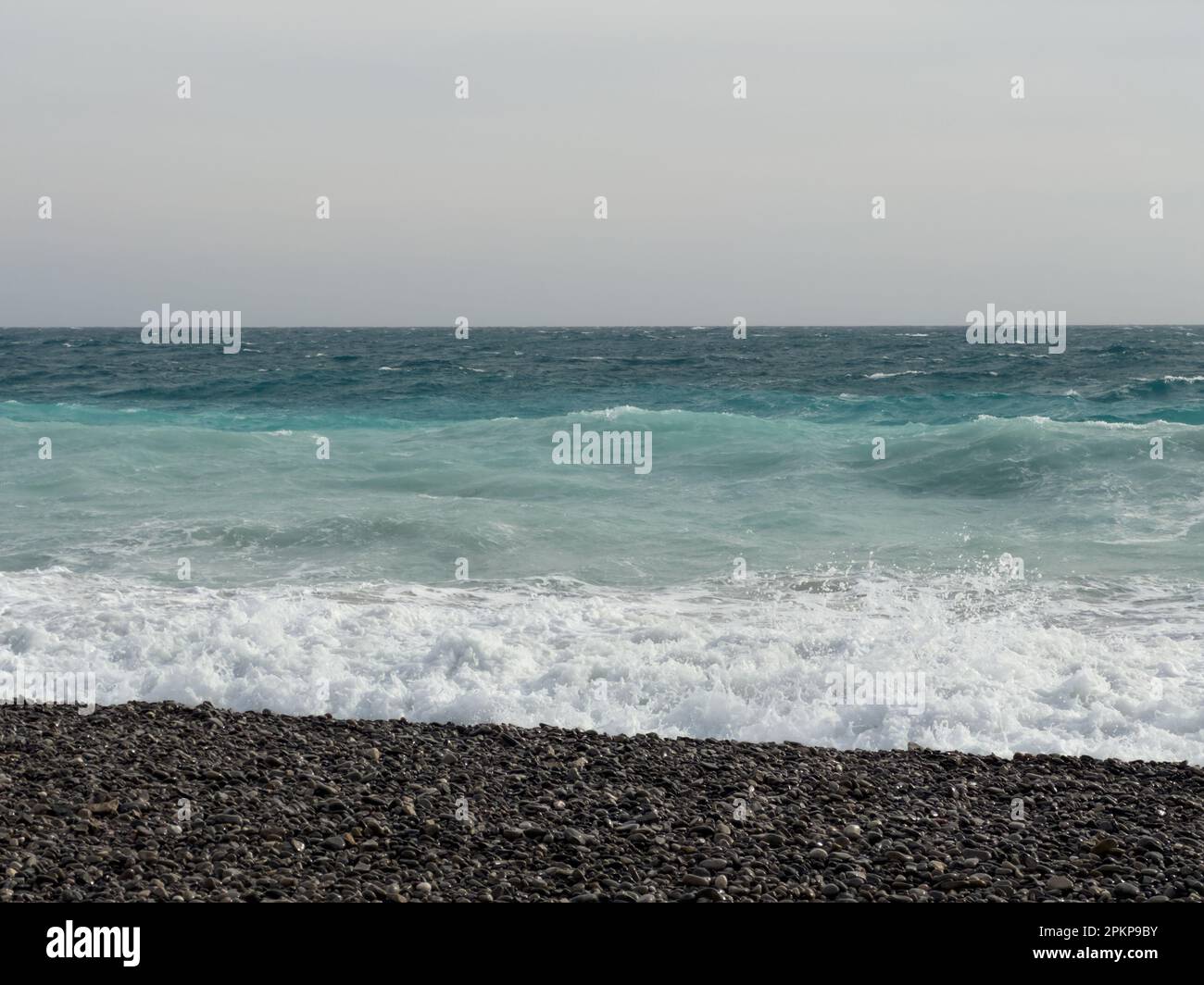 Pebble beach of Nice, France with azure waves of mediterranean sea ...