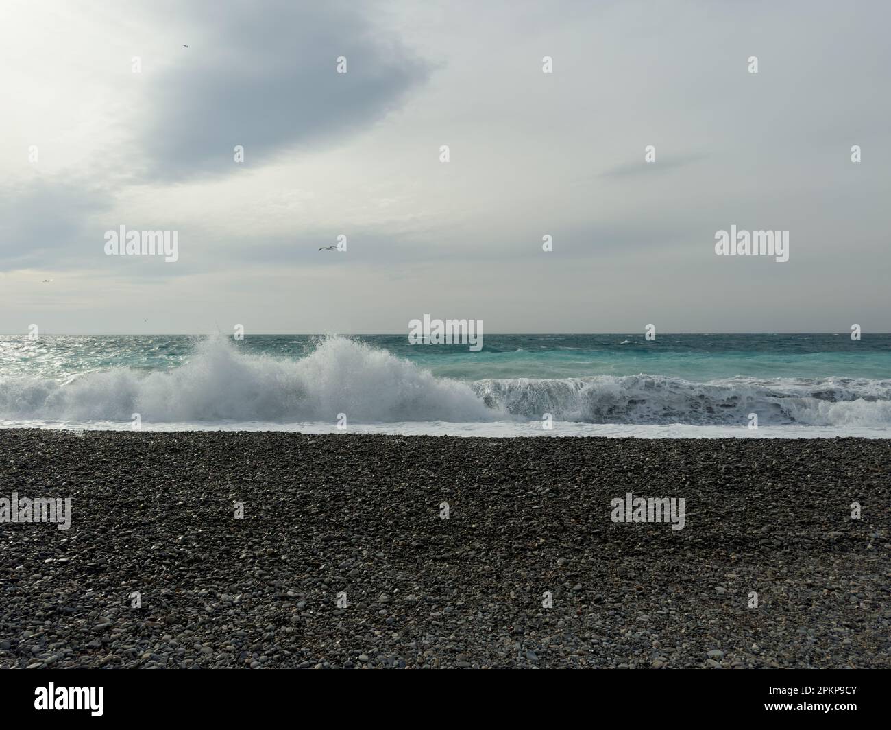Pebble beach of Nice, France with azure waves of mediterranean sea ...