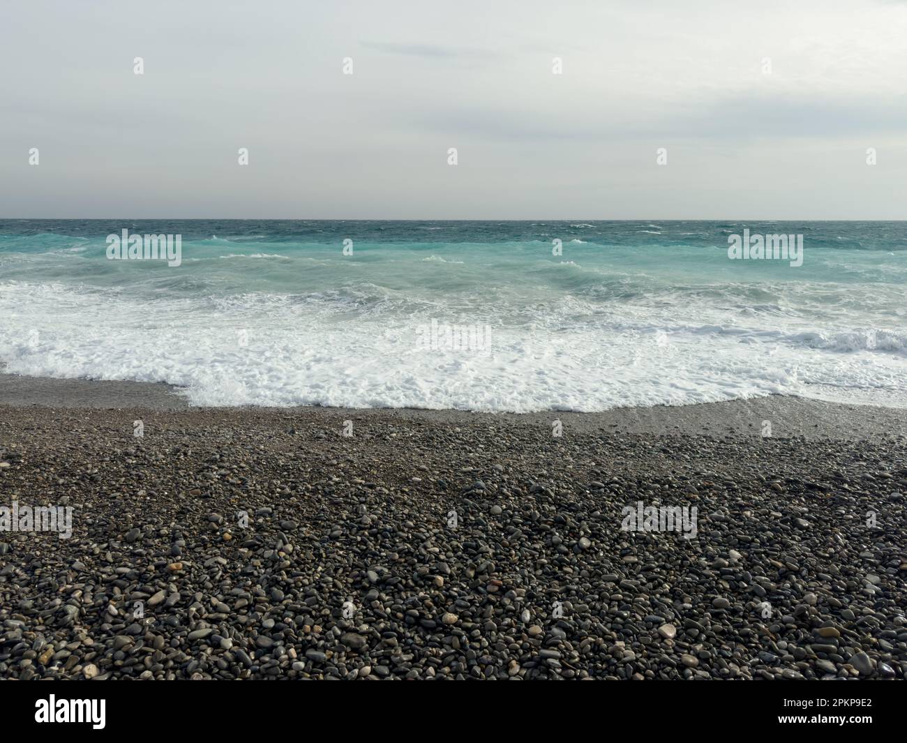 Pebble beach of Nice, France with azure waves of mediterranean sea ...