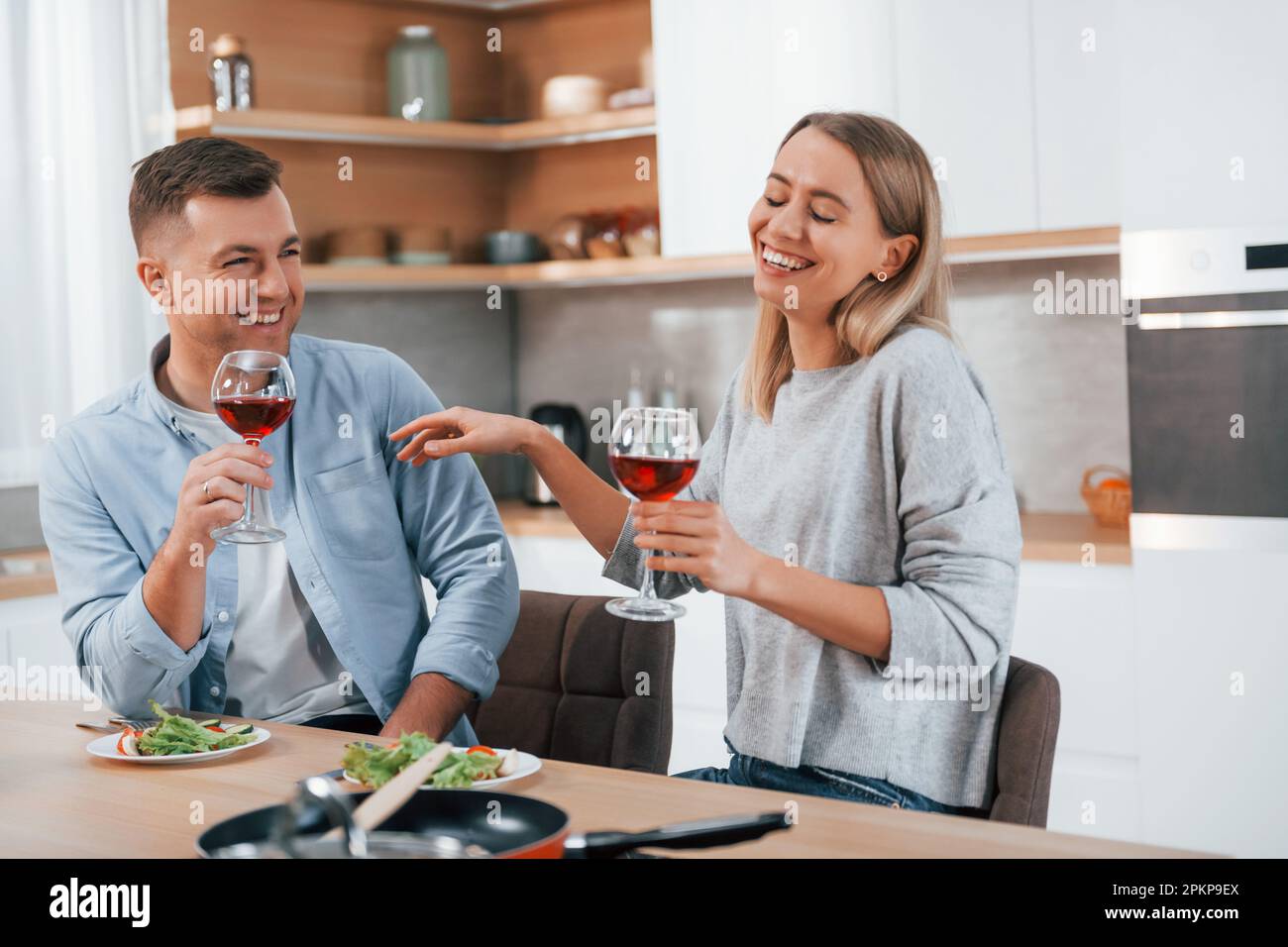 Tasting delicious food. Couple at home on the modern kitchen Stock ...