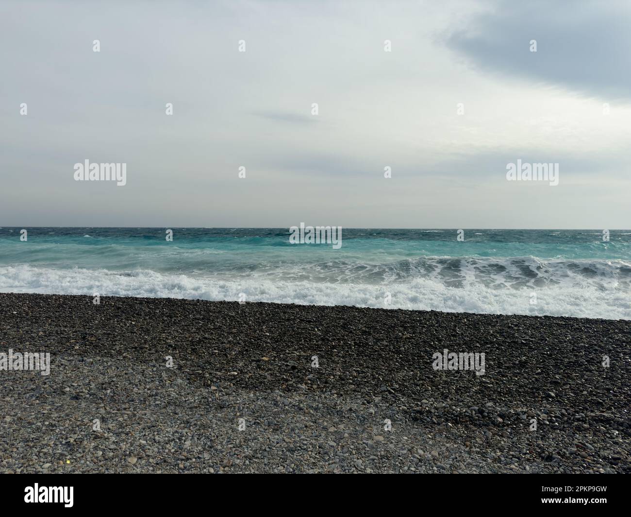 Pebble beach of Nice, France with azure waves of mediterranean sea ...