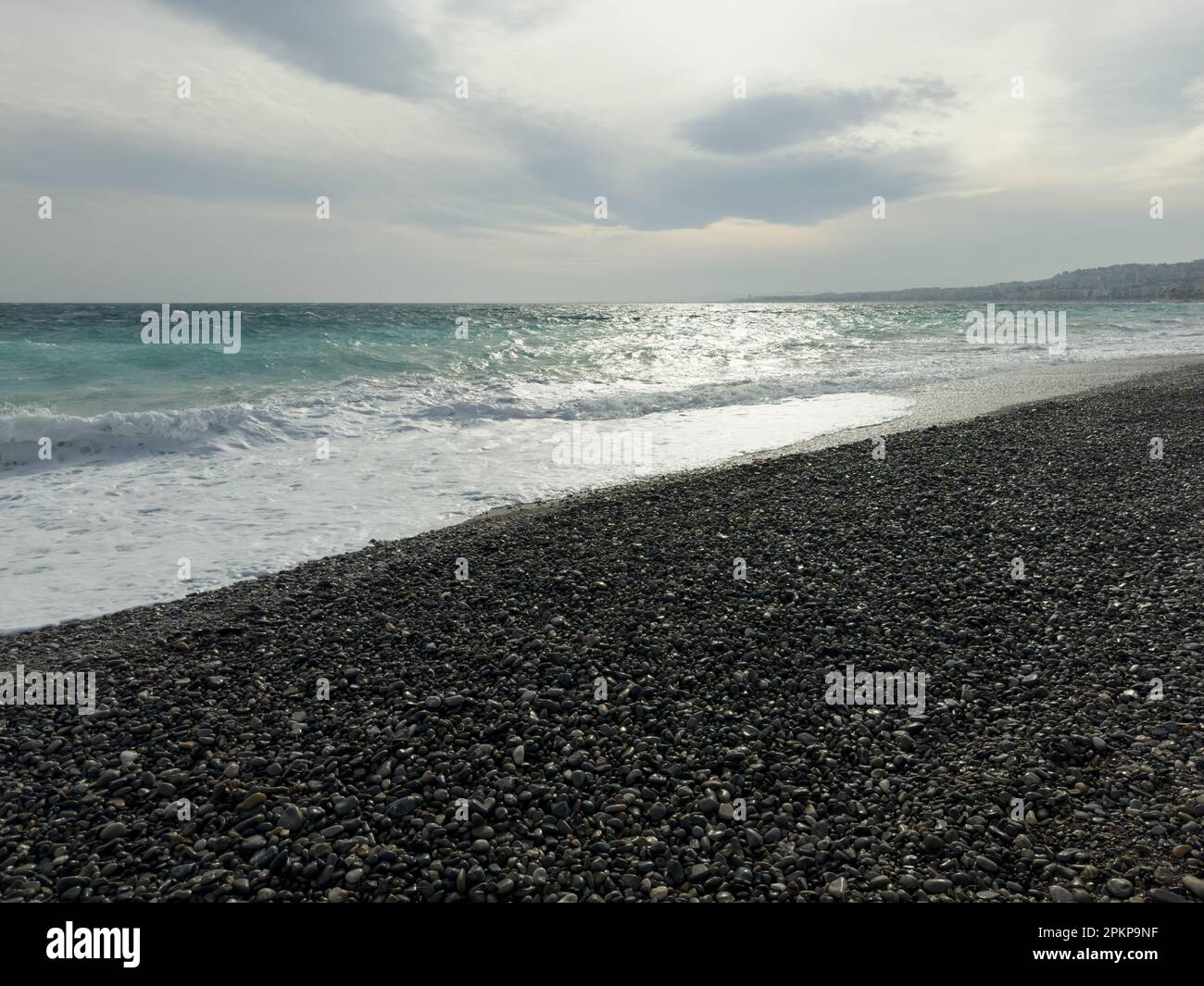Pebble beach of Nice, France with azure waves of mediterranean sea ...