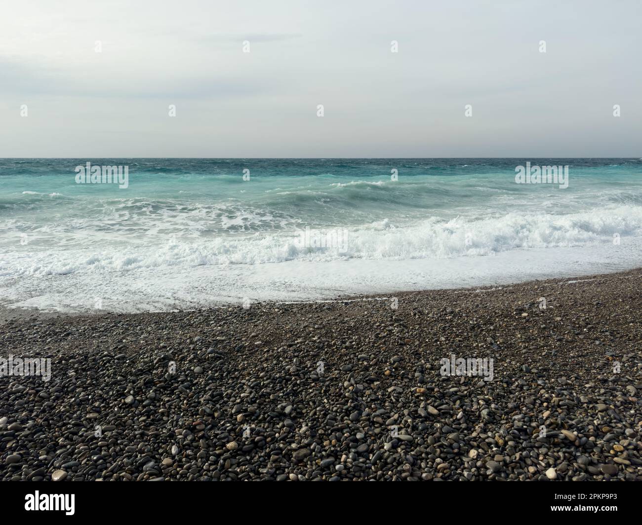 Pebble beach of Nice, France with azure waves of mediterranean sea ...