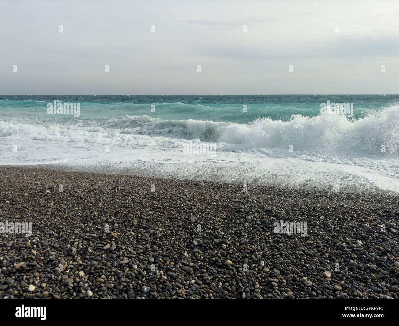 Pebble beach of Nice, France with azure waves of mediterranean sea ...