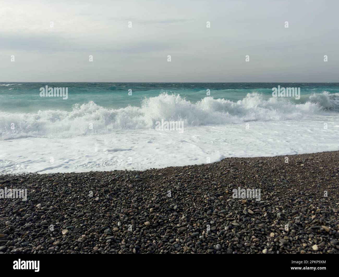 Pebble beach of Nice, France with azure waves of mediterranean sea ...