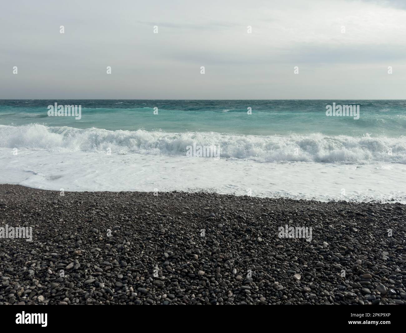 Pebble beach of Nice, France with azure waves of mediterranean sea ...
