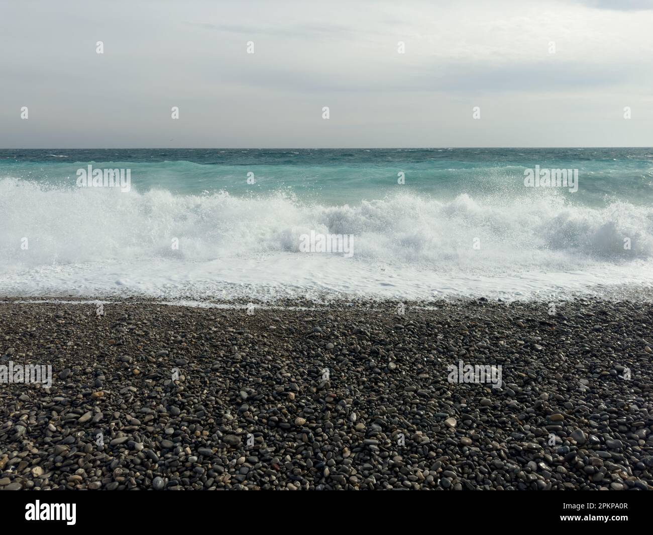Pebble beach of Nice, France with azure waves of mediterranean sea ...
