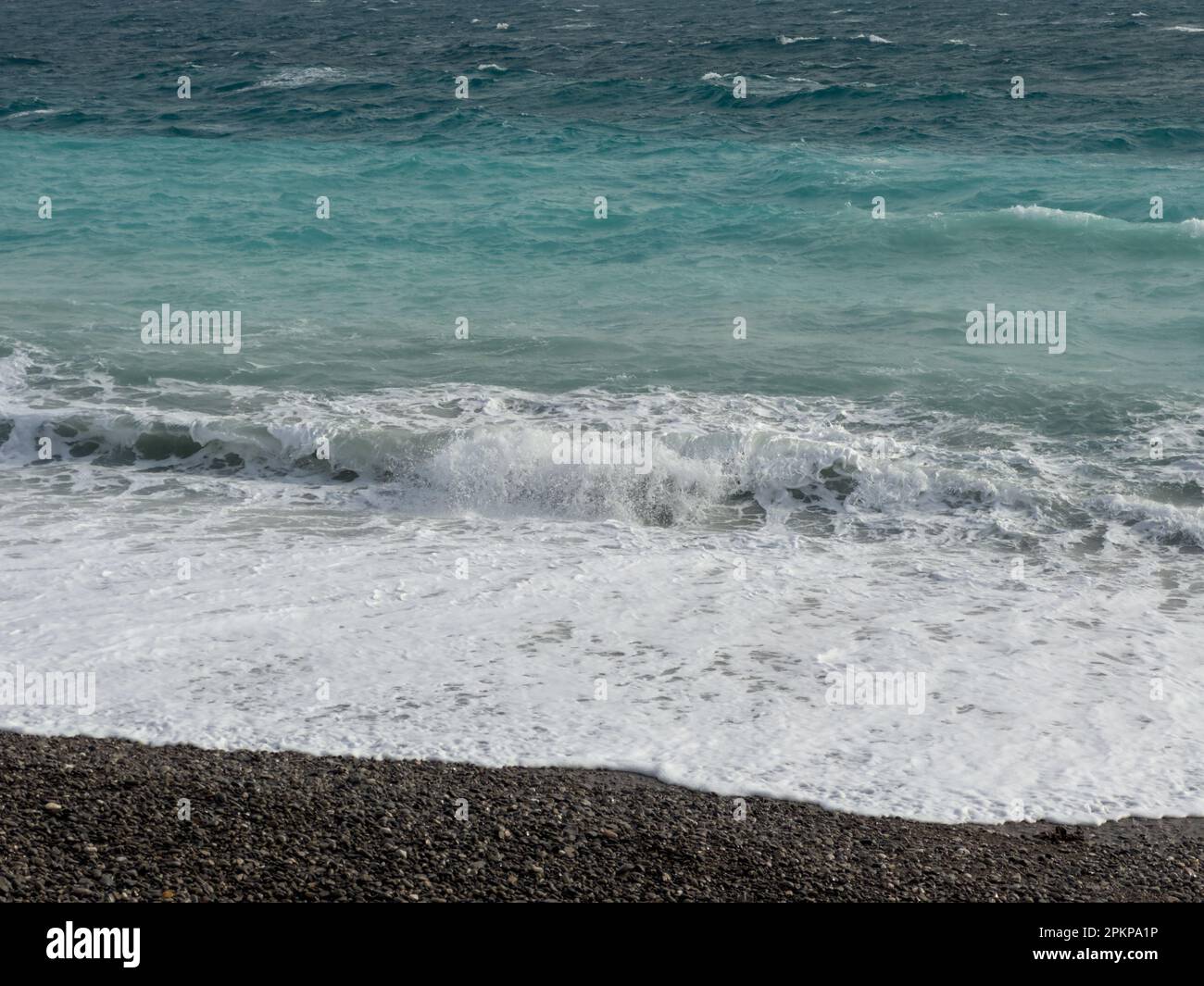 Pebble beach of Nice, France with azure waves of mediterranean sea ...