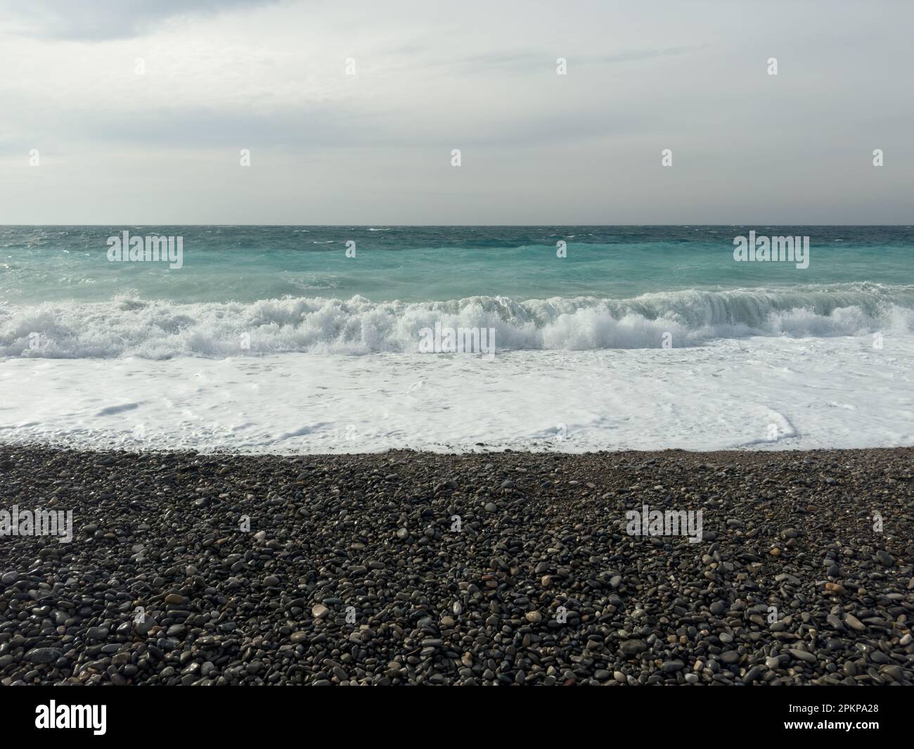 Pebble beach of Nice, France with azure waves of mediterranean sea ...