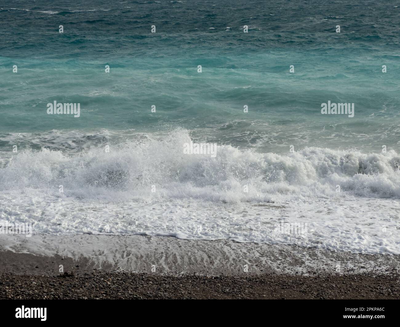 Pebble beach of Nice, France with azure waves of mediterranean sea ...