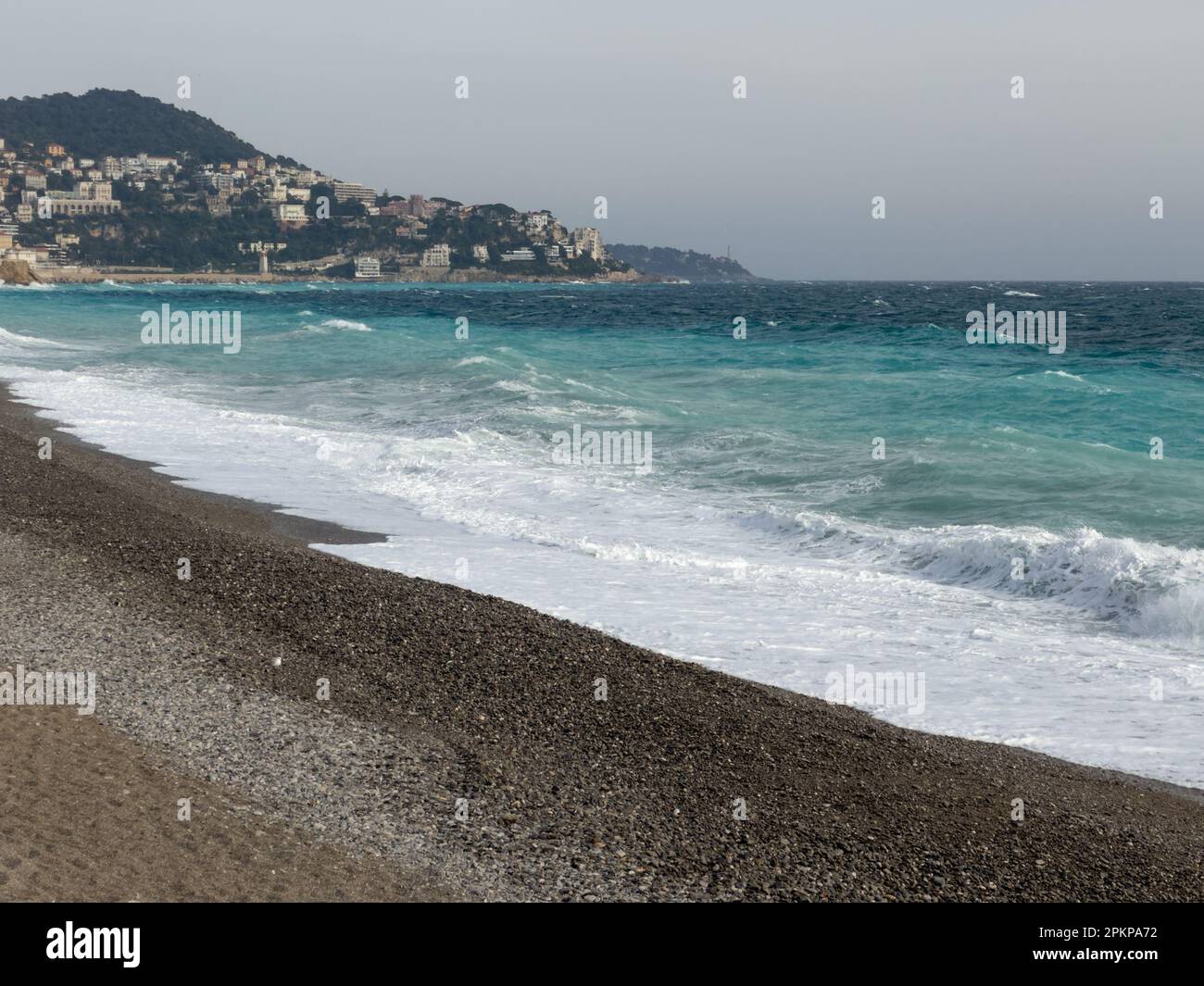 Pebble beach of Nice, France with azure waves of mediterranean sea ...