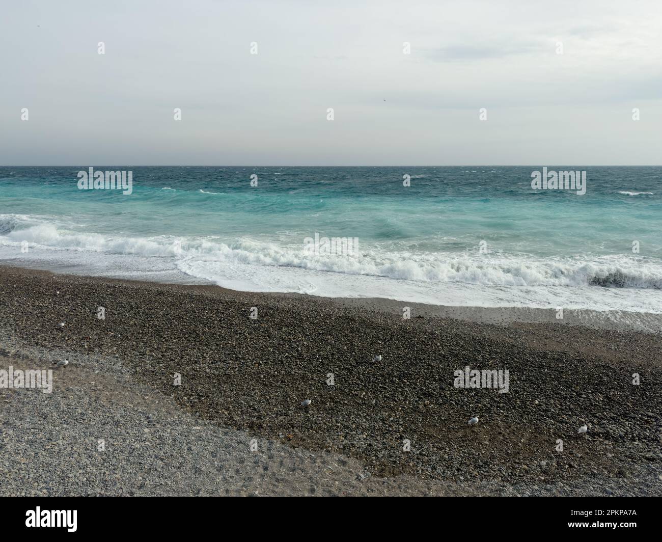 Pebble beach of Nice, France with azure waves of mediterranean sea ...