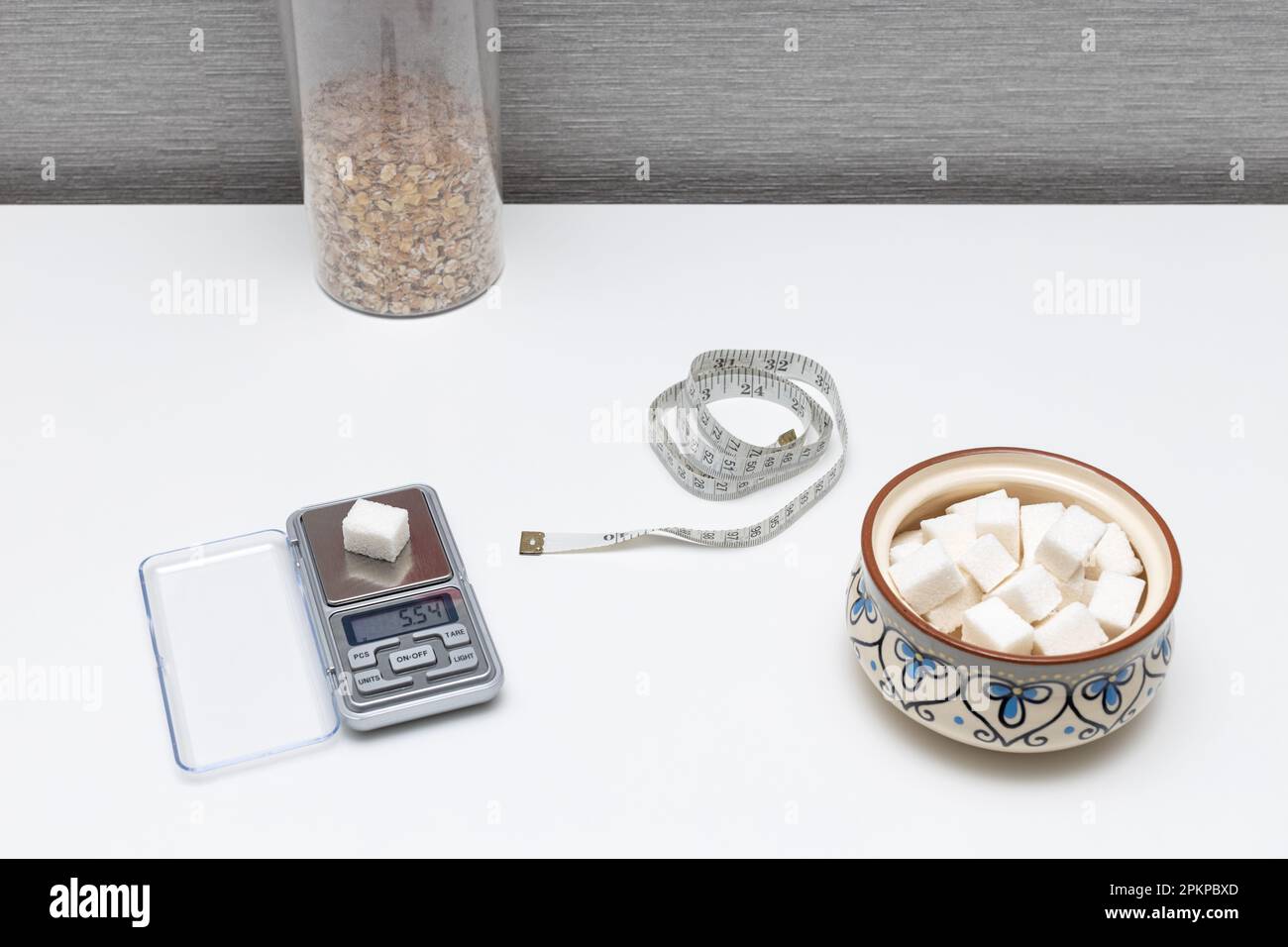 a sugar cube lies on a small scale. white sugar cubes. sugar control. healthy lifestyle. High ...