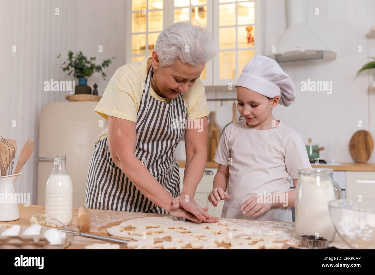 Happy family in kitchen. Grandmother granddaughter child cutting ...