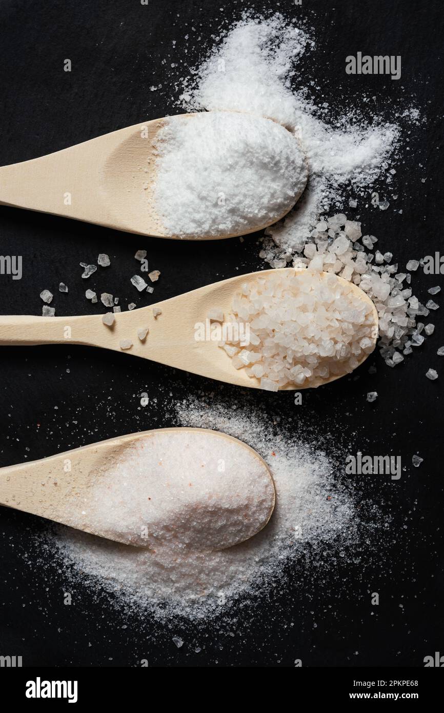 Three types of salt on a black background. Sea, himalayan and table ...