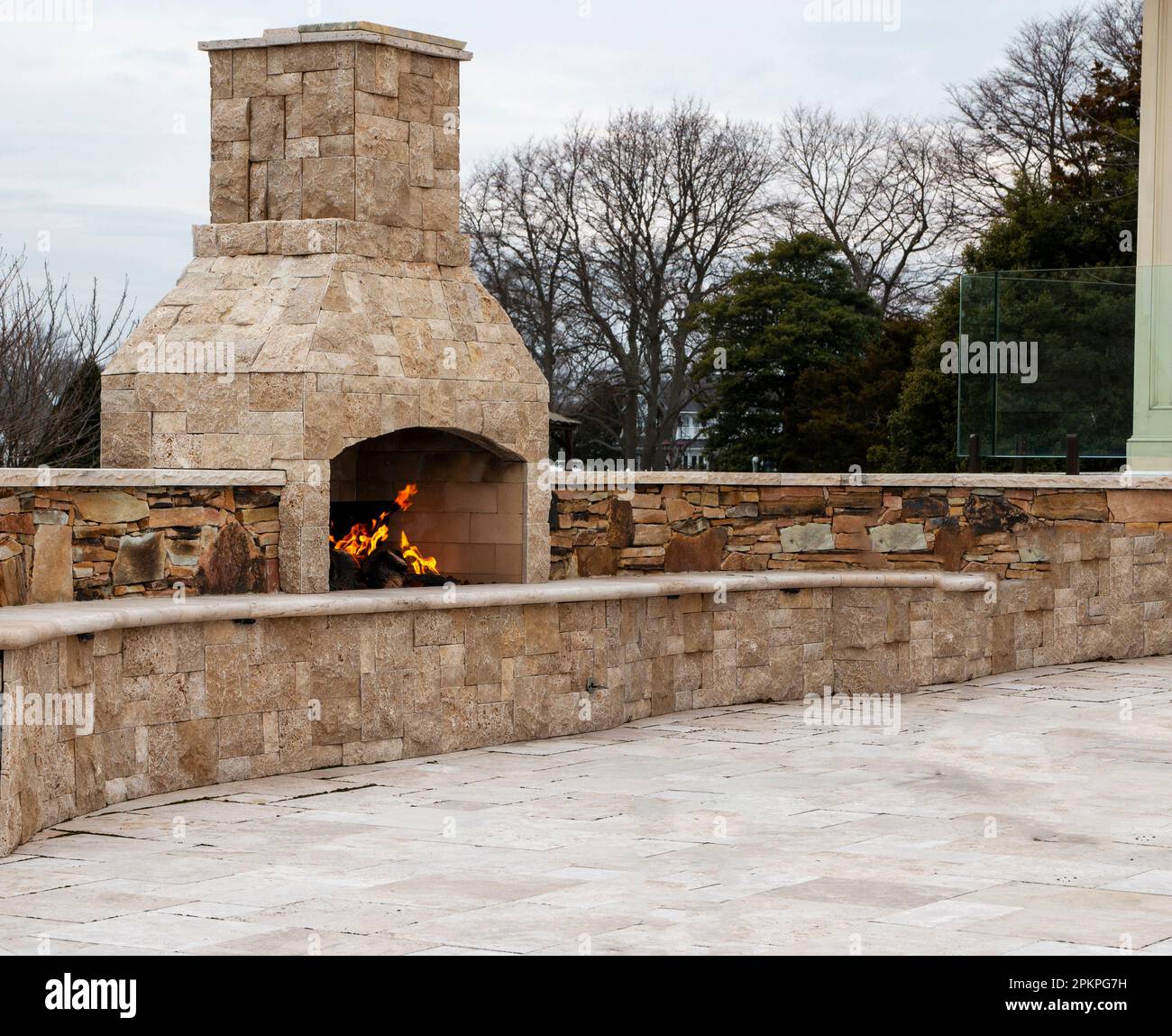Paving stone patio with a burning stone fireplace and no people Stock ...