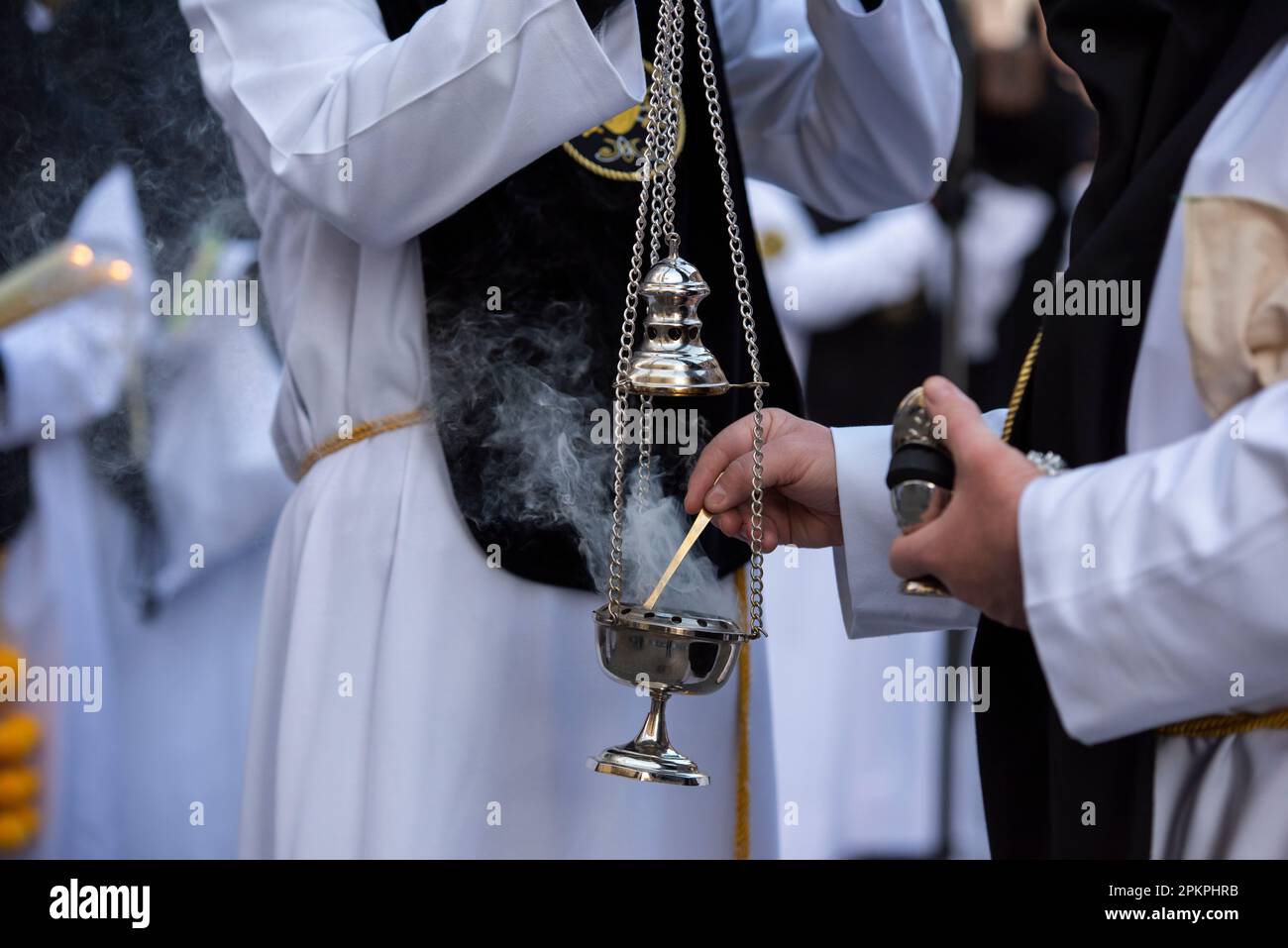 A brotherhood member lights a censer during the procession of Our Lady ...