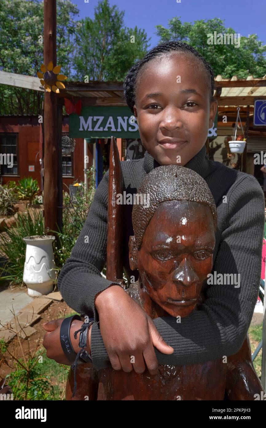 14 Year old Nokwanda Ntuli poses at the Kwantu Village with a wooden ...