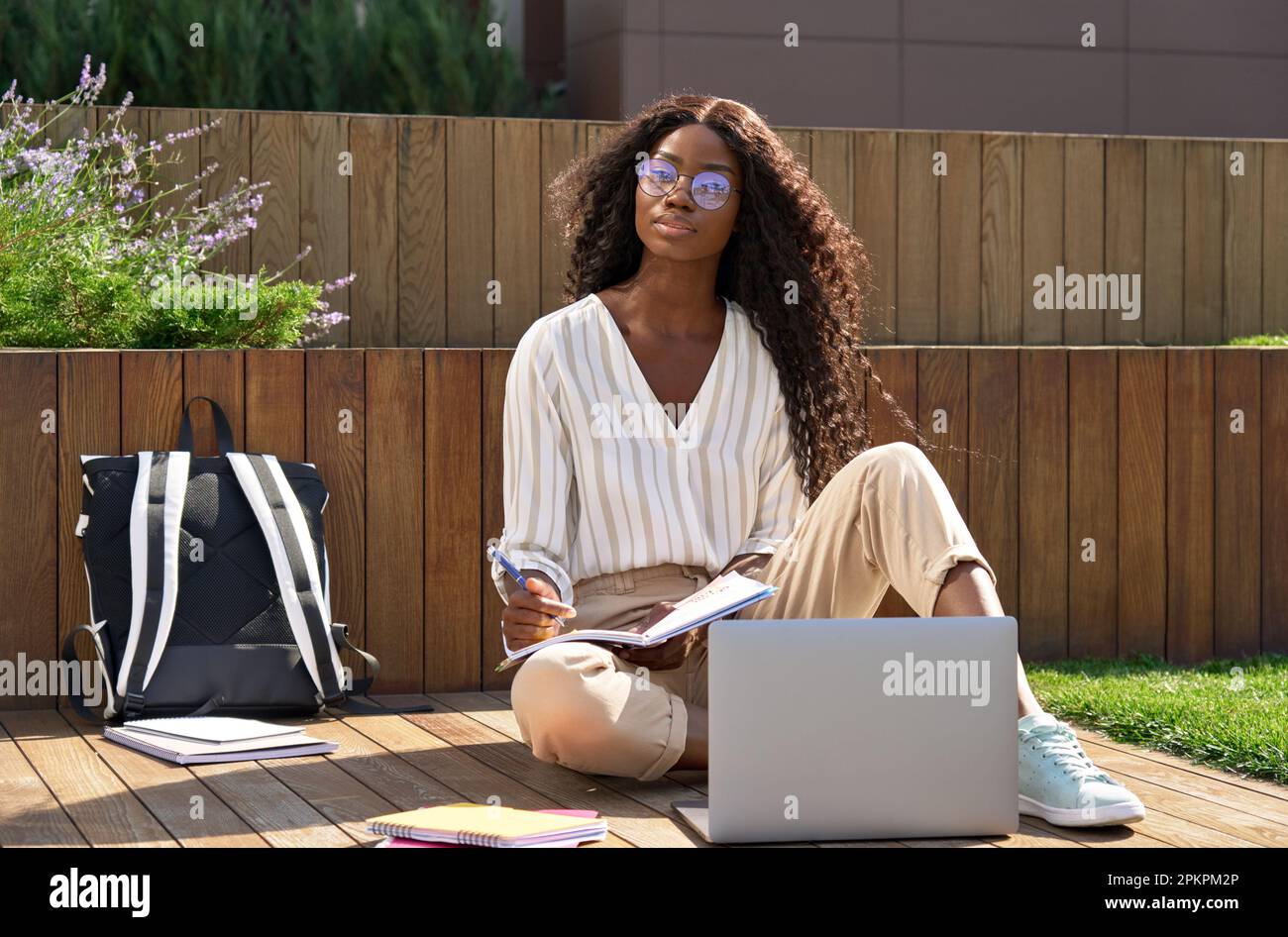 Young black woman university student learning online outdoors, portrait ...