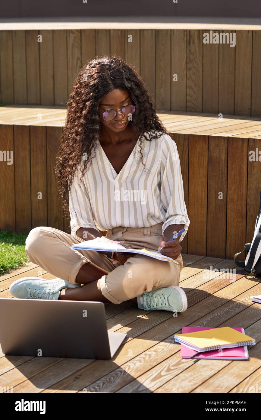 African young woman student writing notes elearning using laptop ...