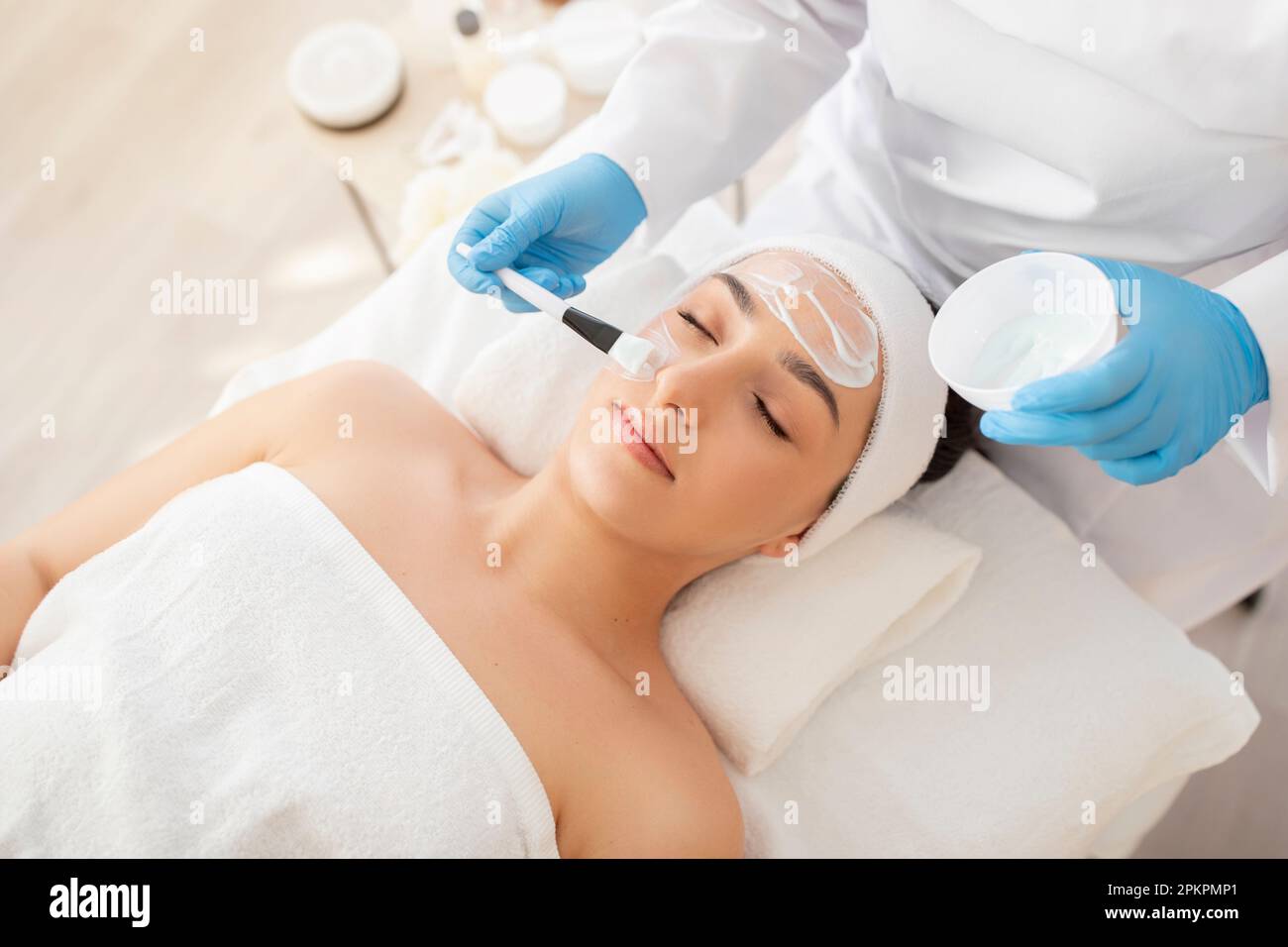 Professional Cosmetologist Doctor Applying Moisturising Mask On Face Of ...